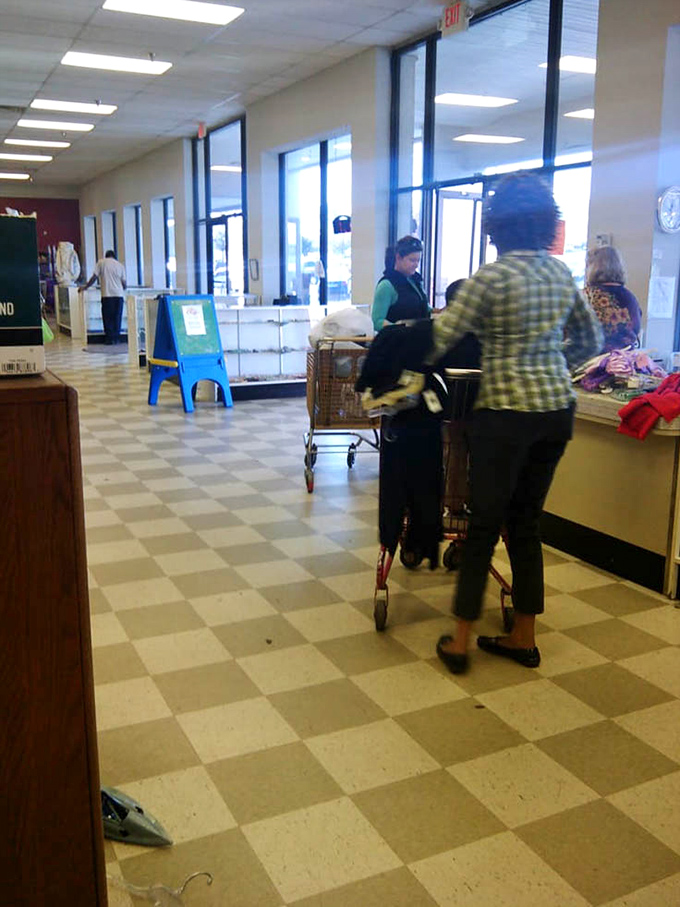 The checkered floor creates a chess board where shoppers strategically maneuver their carts, plotting their next magnificent move.