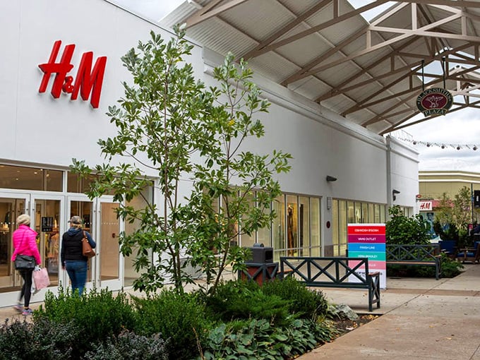 H&M's bold red signage pops against the clean white façade, like a siren call to fashion-forward shoppers seeking Scandinavian style without the IKEA assembly required.