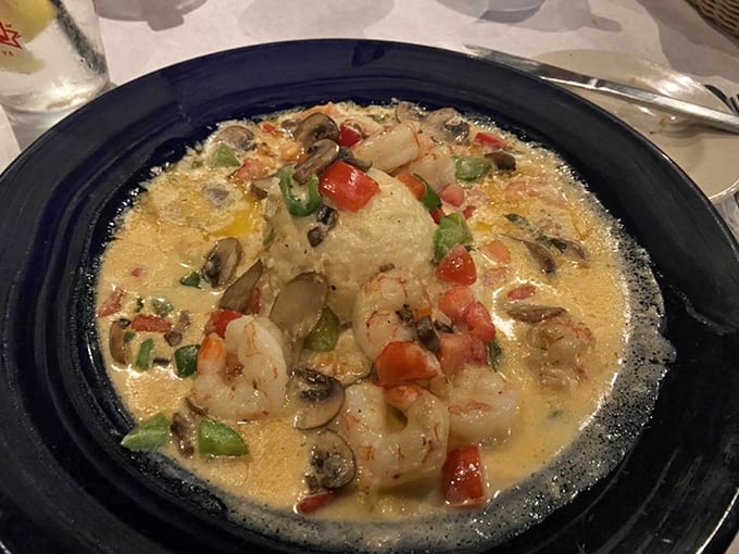 Shrimp and grits elevated to an art form – plump shrimp swimming in creamy goodness with colorful vegetables playing supporting roles.