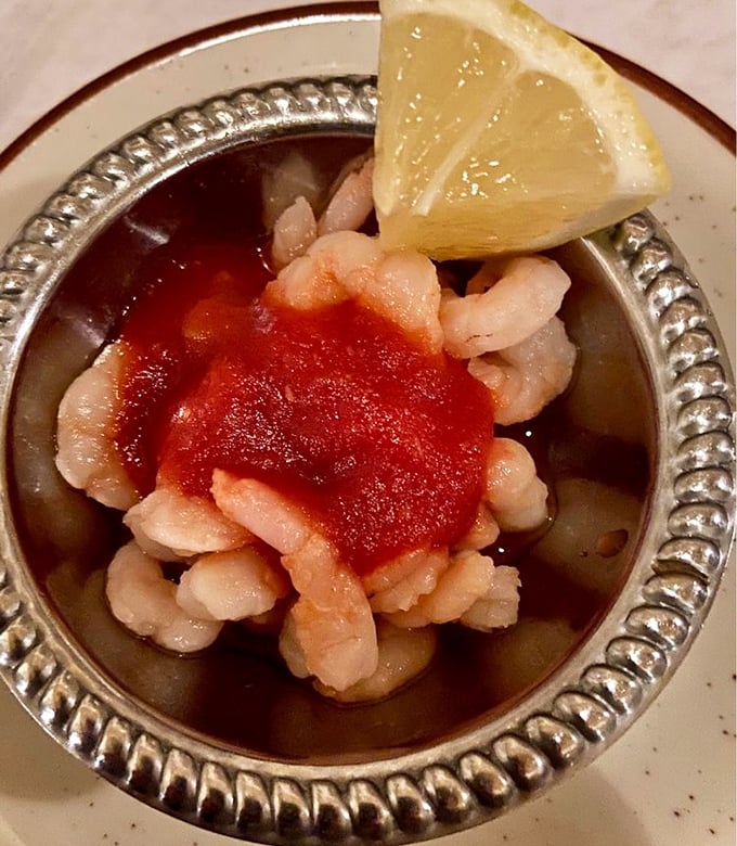The shrimp cocktail arrives like tiny treasures in a silver chalice—plump, pristine crustaceans that taste like they jumped from ocean to plate with just a brief detour through heaven.