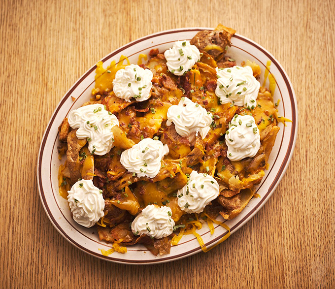 Loaded potato skins crowned with whipped cream rosettes—proof that sometimes the best culinary ideas sound completely absurd until you taste them.