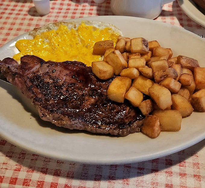 The holy trinity of breakfast: perfectly seared country ham, sunny-side-up eggs, and home fries that could make a potato proud.