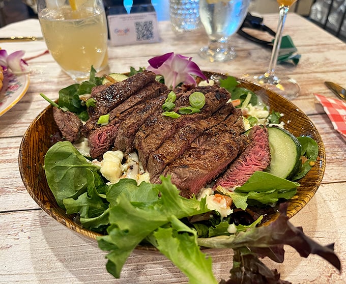 Perfectly seared steak atop fresh greens—proof that salads don't have to be punishment. This is what vegetables dream of becoming.