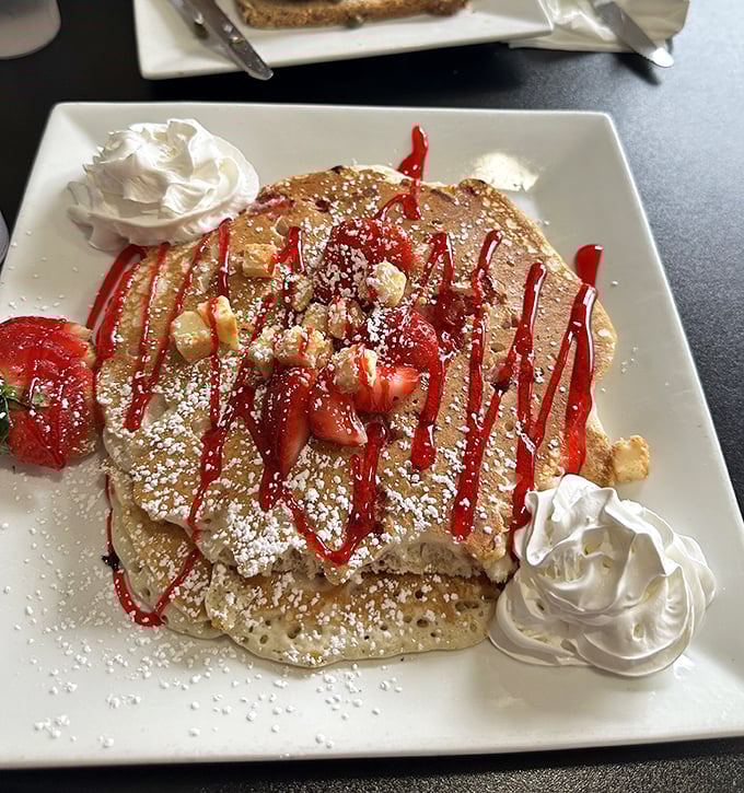 Strawberry pancakes that don't whisper "good morning"—they sing it with a full choir backup. The whipped cream dollops are just showing off.