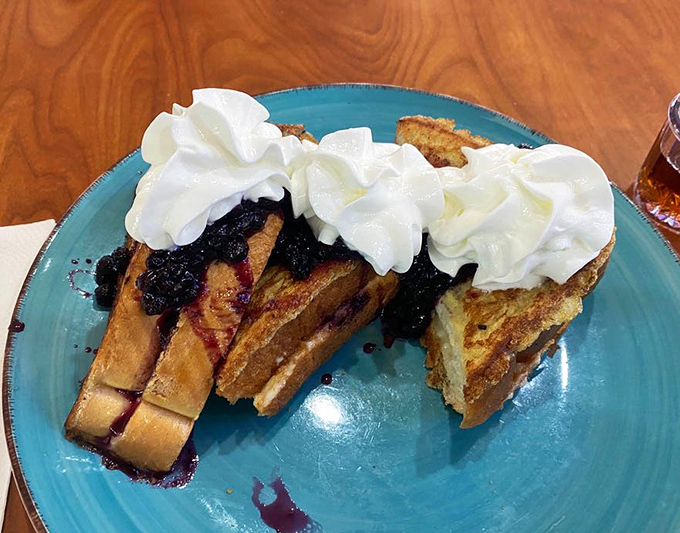 Blueberry-stuffed French toast that makes you question why you'd ever eat anything else for breakfast. The whipped cream isn't optional – it's essential.