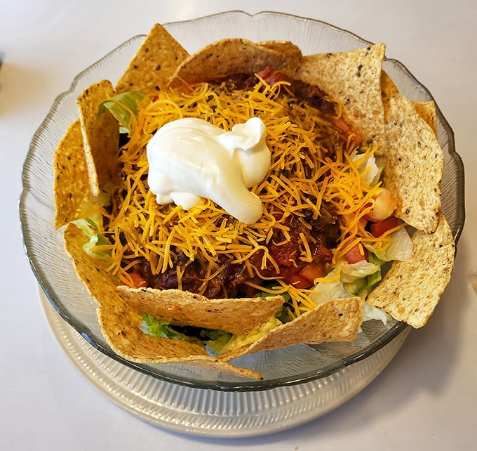 Taco salad that defies gravity – a crunchy, cheesy mountain of goodness topped with a cloud of sour cream.