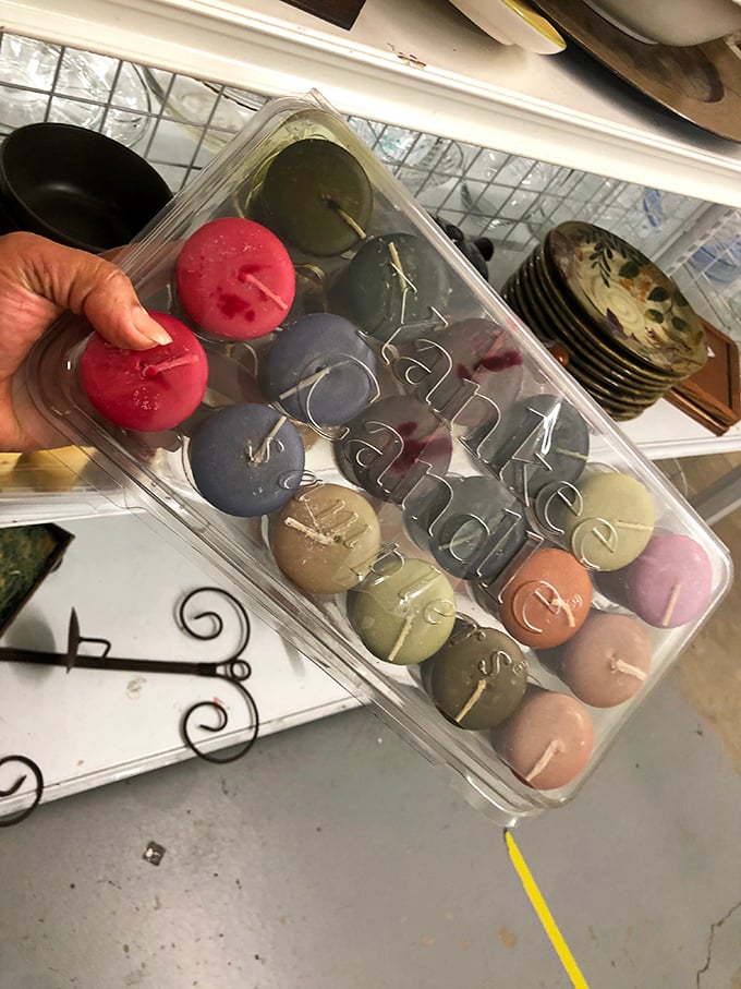 A colorful array of scented candles waiting for their second act. In the thrift world, even half-burned candles get an encore performance.