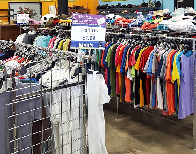 A kaleidoscope of t-shirts awaits at $1.99 each. Like archaeological layers, each rack tells the story of fashion trends, vacation destinations, and corporate team-building events of yesteryear.