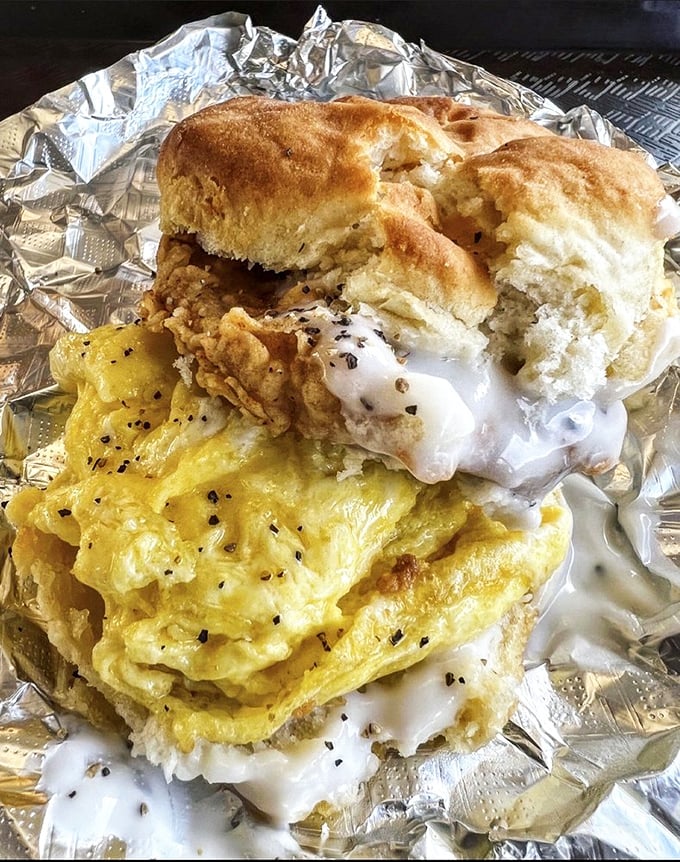 Breakfast architecture at its finest—a golden biscuit embracing eggs, meat, and gravy in a morning masterpiece that puts cereal to shame.