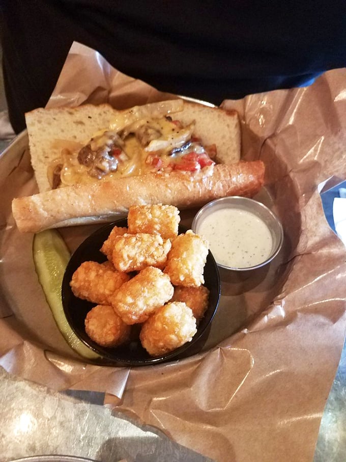 Not all heroes wear capes—some arrive as a tri-tip sandwich dripping with melted cheese, flanked by golden tater tots and a trusty pickle sidekick.