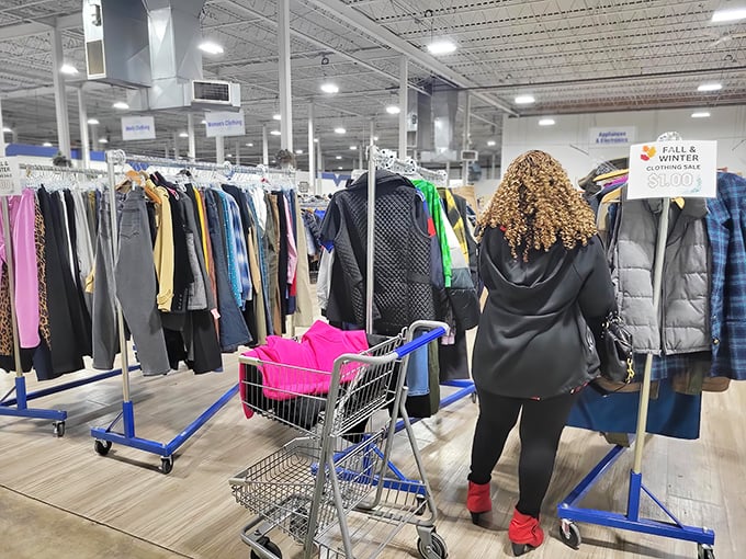 A shopper navigates the clothing forest with purpose—that focused expression is the universal look of someone who just spotted potential vintage gold.