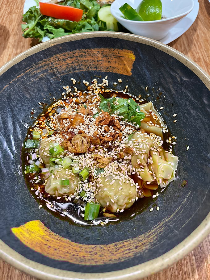 These wontons aren't just dumplings—they're little flavor bombs, perfectly dressed in a savory sauce and topped with sesame seeds that add just the right crunch.