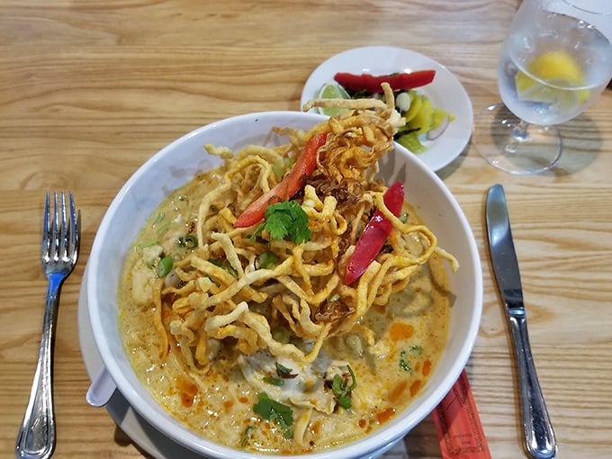 This yellow curry noodle soup arrives like sunshine in a bowl – complete with crispy noodle crown that adds textural fireworks to every spoonful.
