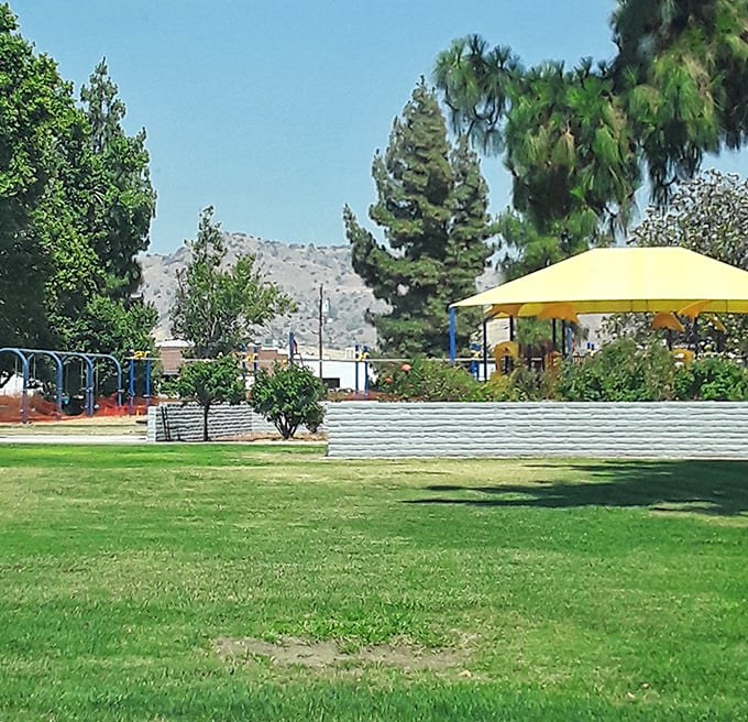This neighborhood park offers the perfect antidote to screen time—actual sunshine, real grass, and yellow shade structures that say "stay awhile" in the universal language of comfort.