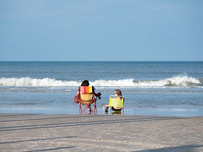 Beach chairs planted firmly in hard-packed sand—nature's perfect recliner with an ocean soundtrack that no luxury spa can replicate.