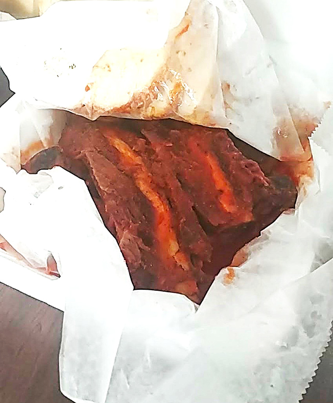 Behold the beef ribs in their paper-wrapped glory. That smoke ring isn't just for show – it's a pink badge of honor.