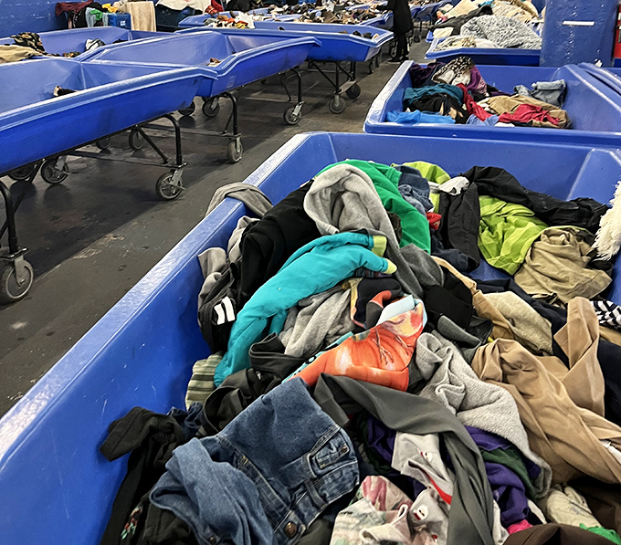 These blue bins aren't just containers—they're portals to possibility. Somewhere in this textile mountain lurks a cashmere sweater with your name on it.