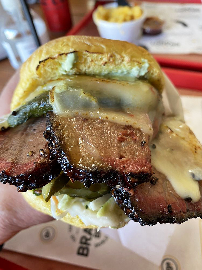 This isn't just a sandwich; it's brisket architecture—layers of smoky meat, pickles, and melty cheese creating the Taj Mahal of lunch options.