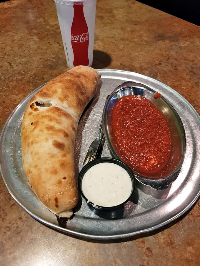 This calzone isn't just folded pizza—it's a self-contained miracle of dough, cheese, and marinara that demands to be savored slowly.