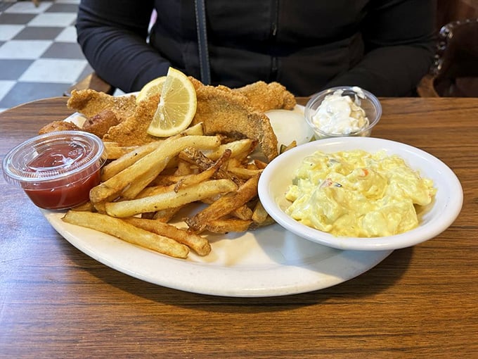 Southern hospitality on a plate: golden-fried catfish with crispy fries and creamy potato salad. Comfort food that hugs your soul.
