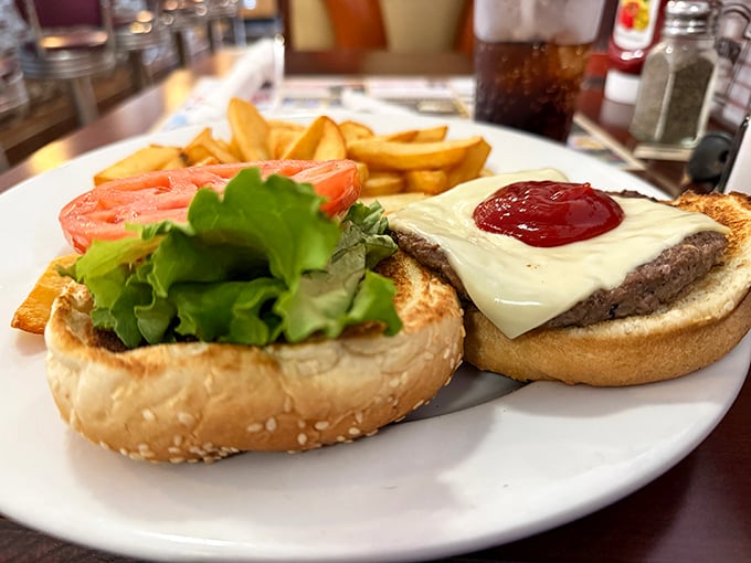 The cheeseburger – humanity's greatest invention after fire and the wheel. This beauty comes with perfectly golden fries that demand to be savored.