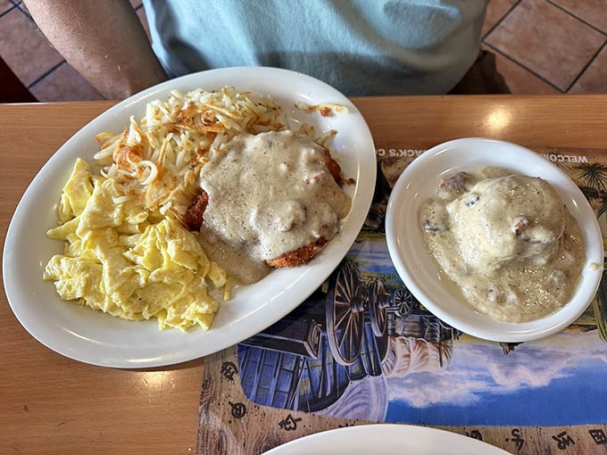 Country-fried steak smothered in gravy alongside scrambled eggs—comfort food that makes you want to hug your plate before devouring every last morsel.
