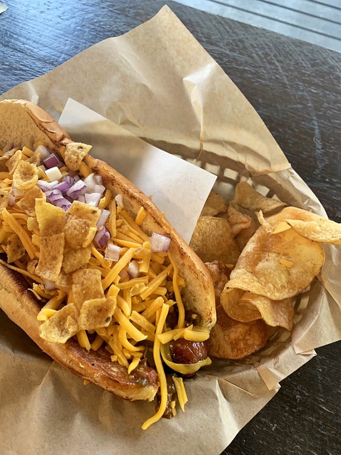 The holy grail of comfort food—a chili dog topped with melted cheese, crunchy chips, and diced onions that would make your cardiologist wince and your taste buds sing.