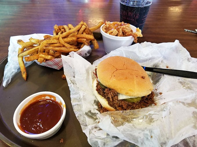 The legendary chopped pork sandwich in its natural habitat—surrounded by crispy fries and a side of that magical sauce that haunts your dreams.