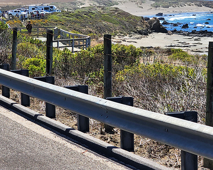 The highway's guardrail offers a front-row seat to nature's greatest show – the endless dance between land and sea.