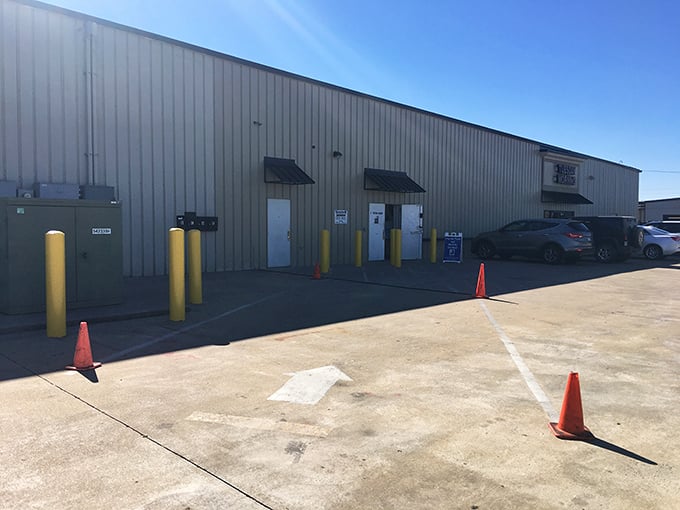 Yellow bollards guard the donation drop-off zone where your clutter becomes someone else's treasure—it's the circle of thrift.