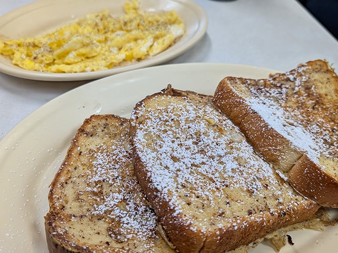 French toast dusted with powdered sugar alongside scrambled eggs—breakfast's perfect marriage. Like morning sunshine on a plate. 