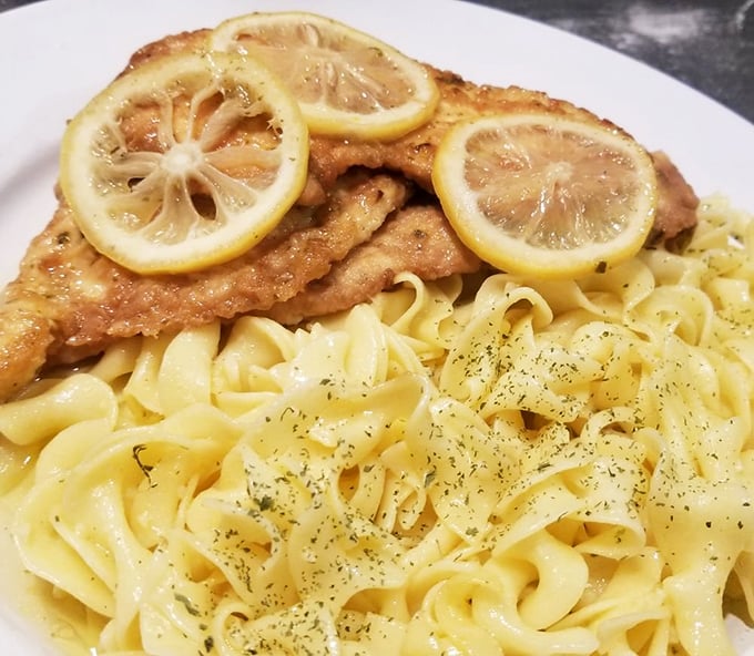 The lemon chicken isn't playing around—those golden cutlets topped with fresh lemon slices over buttery noodles are what food dreams are made of.