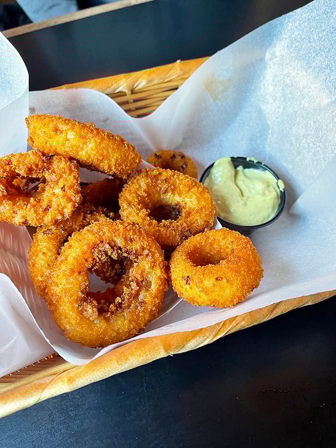 Onion rings with architectural integrity that would make Frank Lloyd Wright proud. Crispy, golden halos of happiness with house-made dipping sauce.