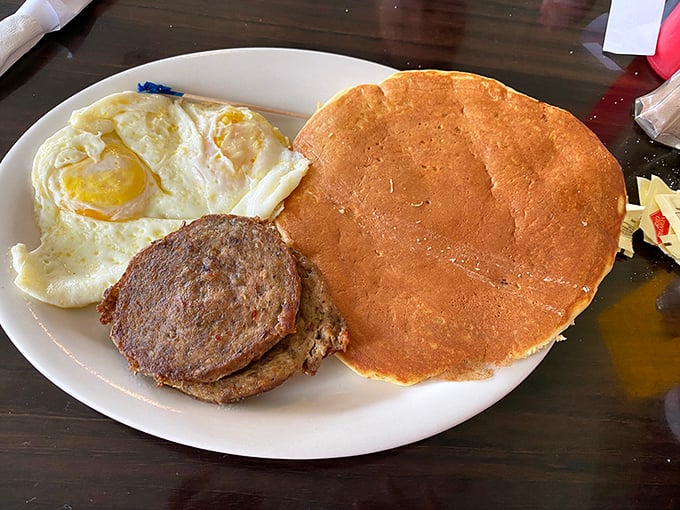 The pancake-to-plate ratio here is gloriously absurd. That sausage patty looks like it's trying to hide, knowing it's been upstaged by carb perfection.
