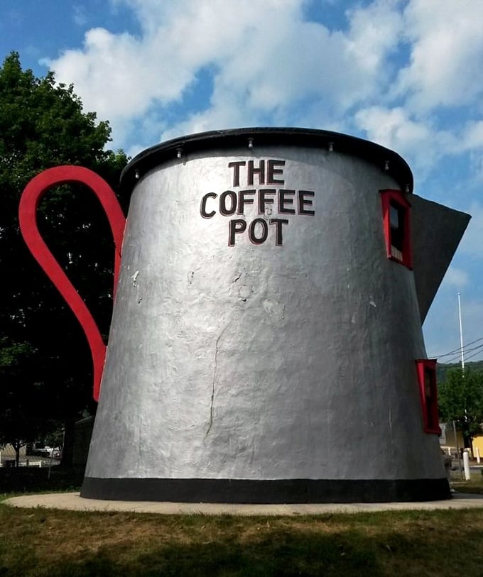 That magnificent red handle isn't just for show—it's architectural whimsy at its finest, curving dramatically against the silver pot like a sculptural exclamation point.