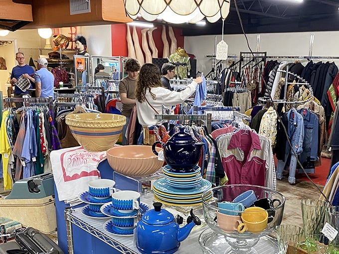 Treasure hunters navigate the aisles while colorful dishware stands sentinel, each piece whispering stories of dinner parties past.