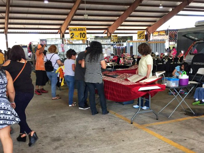 The universal language of flea market negotiation in action. Notice the focused expressions—these shoppers aren't just browsing, they're on a mission.
