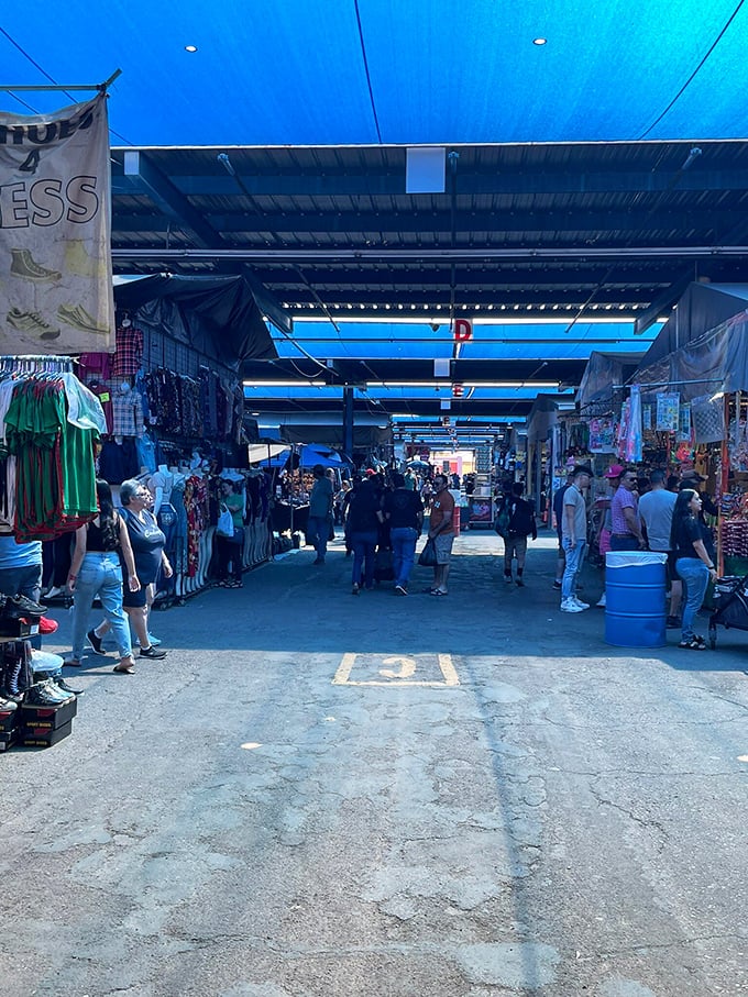 The covered marketplace offers blessed shade and endless browsing opportunities, with blue tarps creating a cool microclimate for serious shopping.
