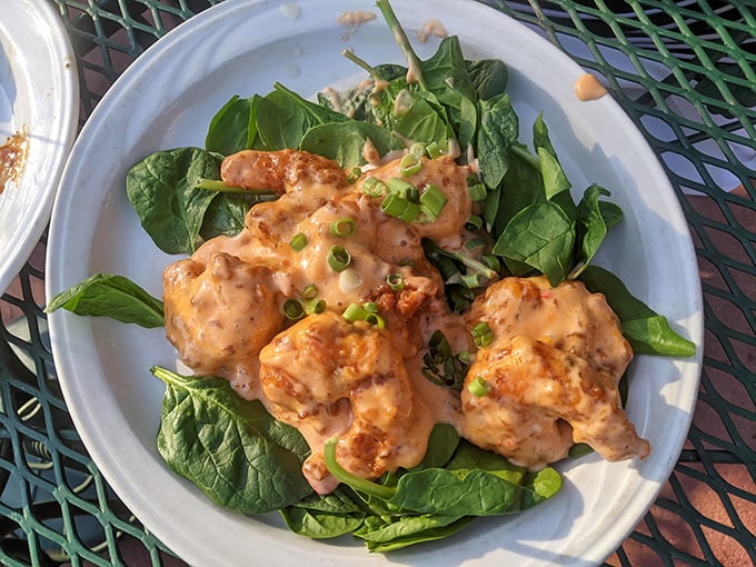 These golden-fried shrimp nestled on fresh spinach aren't just appetizers—they're little crispy ambassadors from the ocean to the prairie.