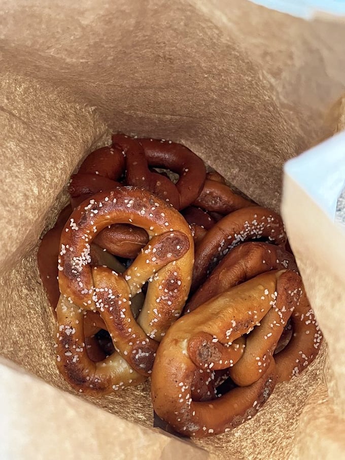 A brown paper bag reveals the motherlode—hand-twisted pretzels with that distinctive mahogany sheen and perfect salt distribution that makes taste buds sing.