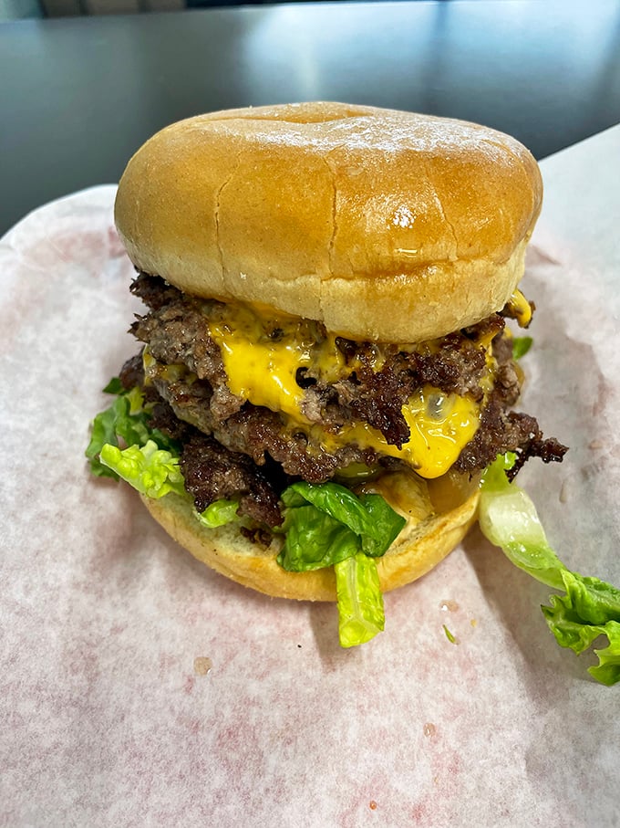 Behold the triple cheeseburger in its natural habitat – a monument to American excess that somehow manages to remain perfectly balanced. Engineering marvel meets lunch.