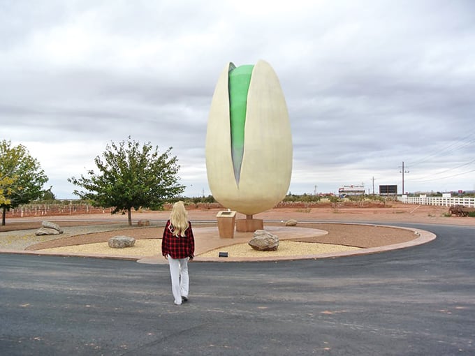 Scale becomes apparent when humans meet monument—this massive nut sculpture turns every visitor into an impromptu photographer.