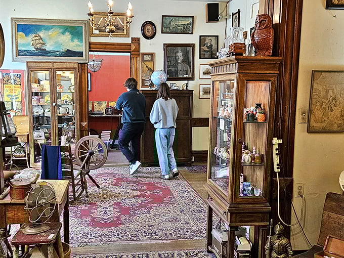 Treasure hunters navigate a room where every wall tells stories—vintage paintings, ornate furniture, and the thrill of discovery around every corner. 