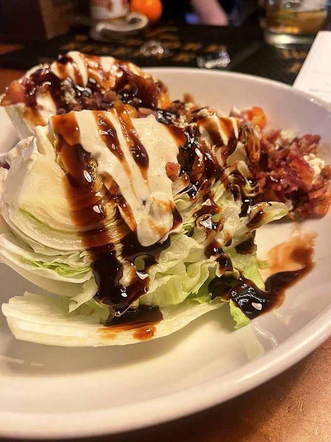 The wedge salad—that steakhouse classic reinvented. Crisp iceberg drizzled with balsamic glaze and blue cheese dressing proves simplicity can be revolutionary when done right.