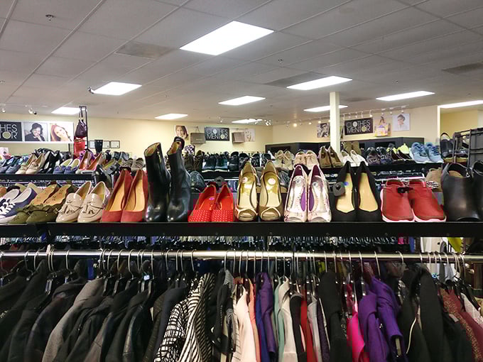Shoes perched above clothing racks create a multi-level shopping experience that rewards those willing to explore every corner.