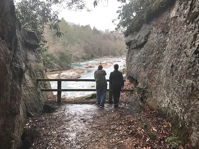 Nature frames this riverside overlook in Buckhannon perfectly. Two visitors pause to appreciate what no smartphone screen could ever truly capture.