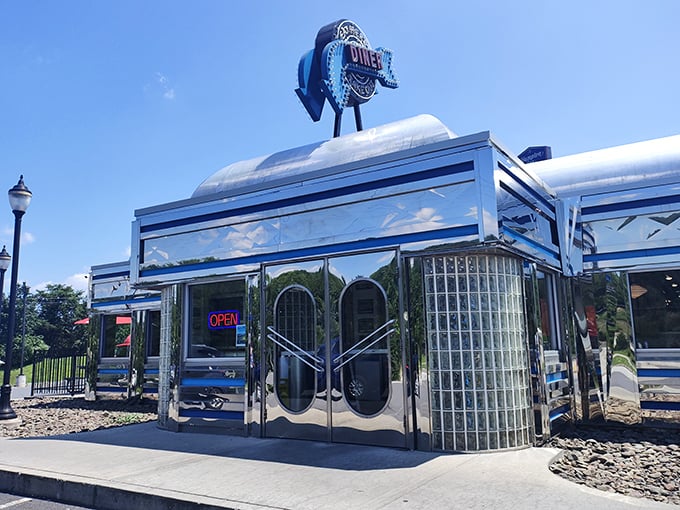 The Pine Grove Diner's gleaming exterior catches sunlight like a mirror, reflecting decades of roadside dining history in its polished stainless steel skin.