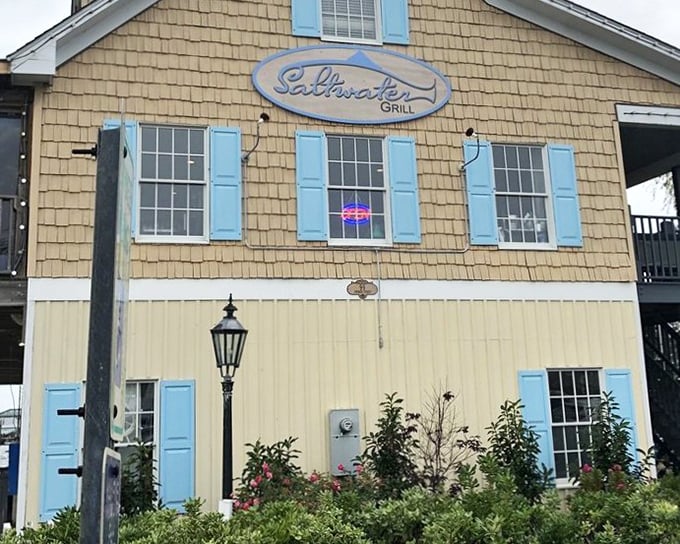 Saltwater Grill's charming beach house exterior with blue shutters promises coastal comfort with a touch of class.