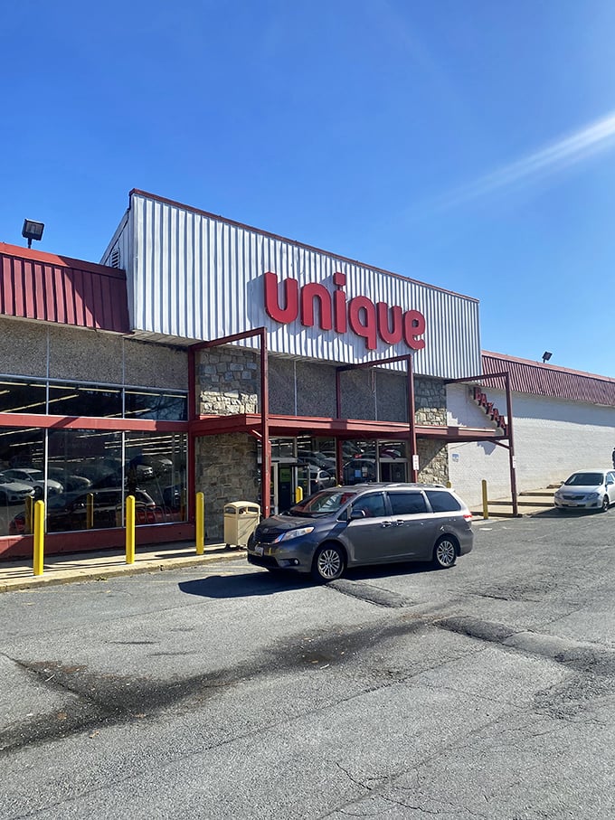 Unique's distinctive red signage against industrial white siding—architectural minimalism meets maximum savings inside.