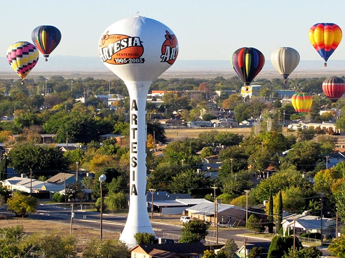 Floating above inflation! Artesia's iconic water tower stands tall like the town's reputation for keeping prices grounded while hot air balloons soar overhead.